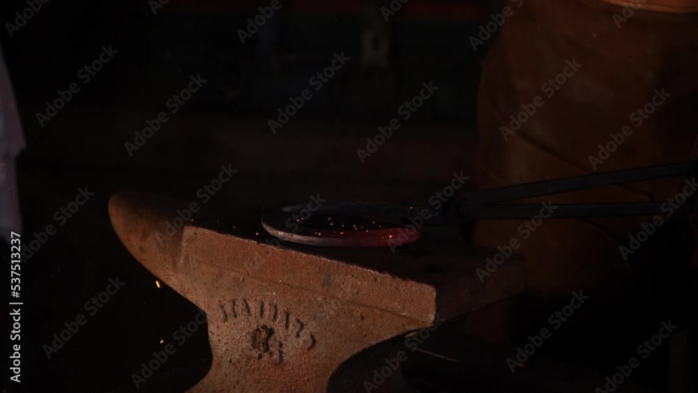 Close-up, Blacksmith cowboy man work, the horseshoe is worked on anvil ...