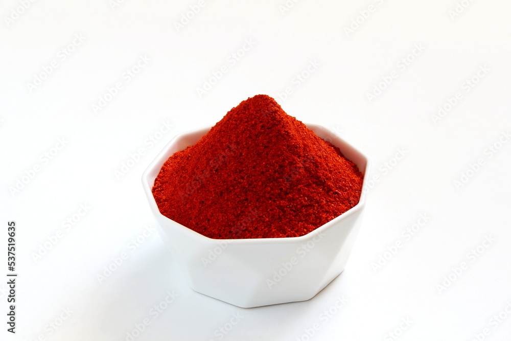 heap of dry organic kashmiri red chili pepper powder isolated in bowl ...