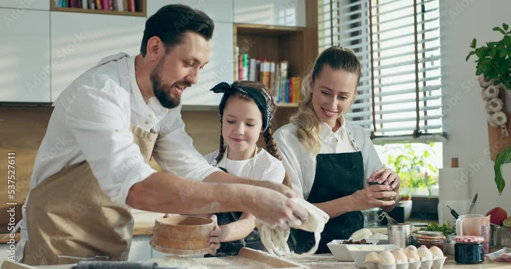 Curious preschooler kid girl helping father sieving flour with dad ...