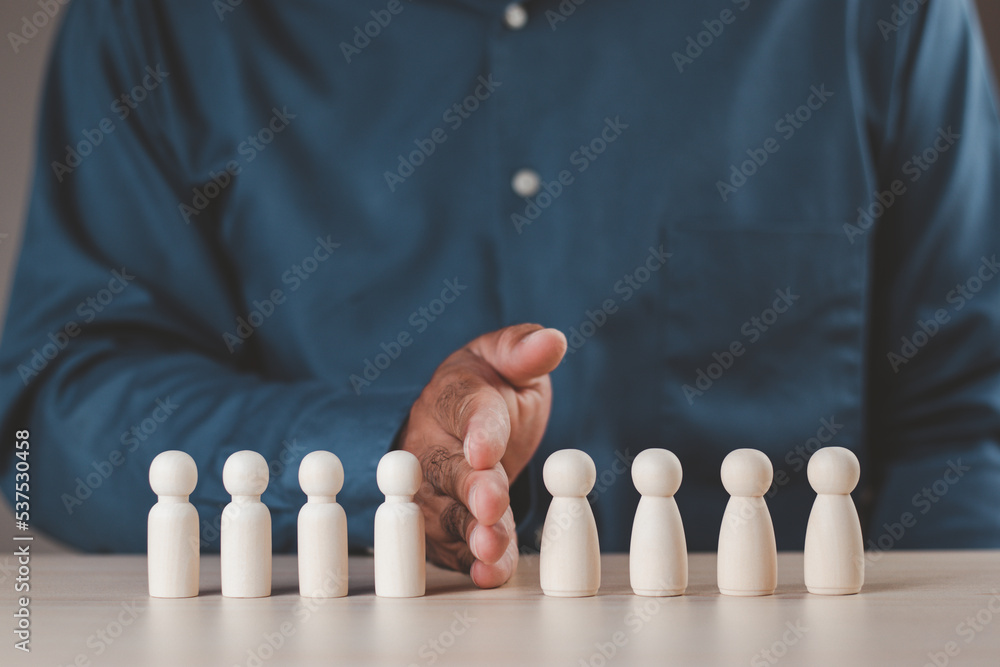 A businessman's hand divides the wooden figure into two sides, a man ...