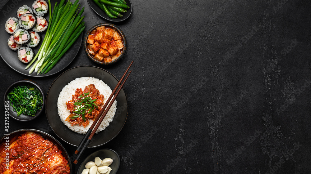 Korean food on a black background. Rice, kimchi, kimbap, pickled radish ...