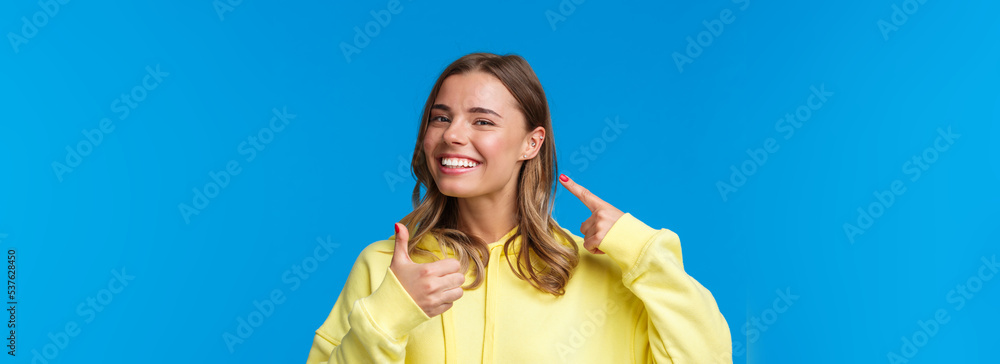 Cheerful and pleased, satisfied good-looking european female pointing ...