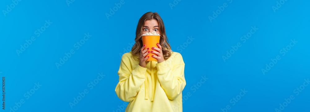 Leisure, fun and youth concept. Thrilled scared blond girl hiding ...