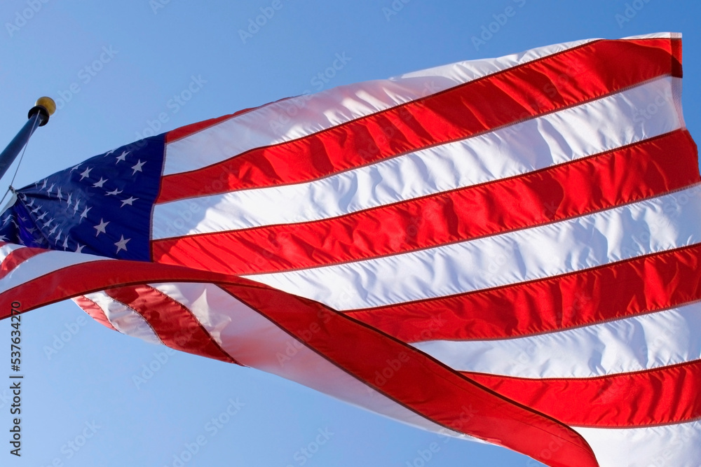 american flag flying in blue sky Stock Photo | Adobe Stock