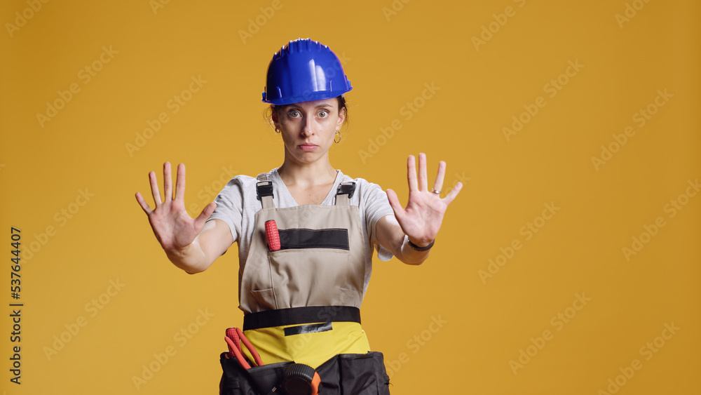 Portrait of construction worker doing stop sign with palm, advertising ...