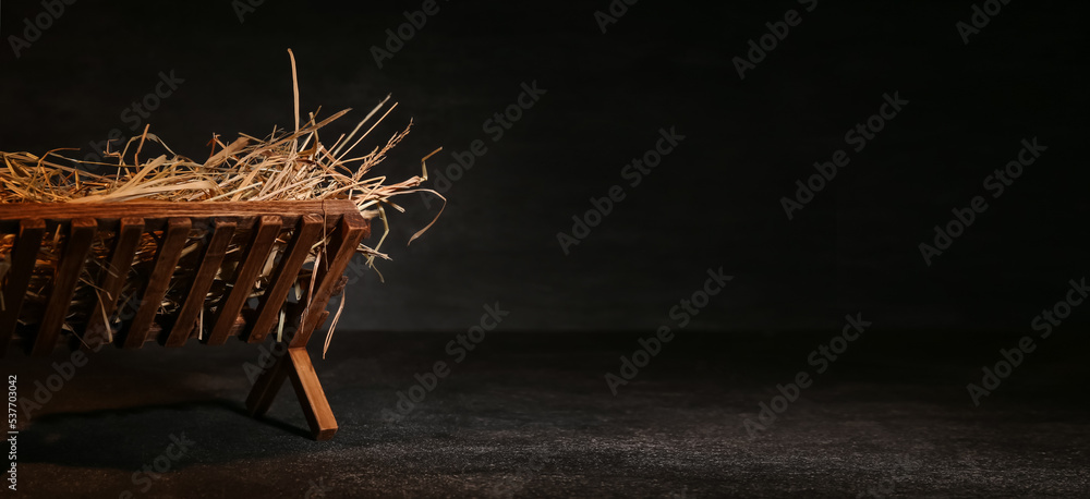 Manger with hay on dark background with space for text. Concept of ...