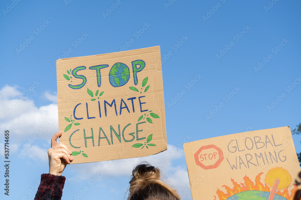 Protesters holding signs with slogans Stop Climate Change and Stop ...