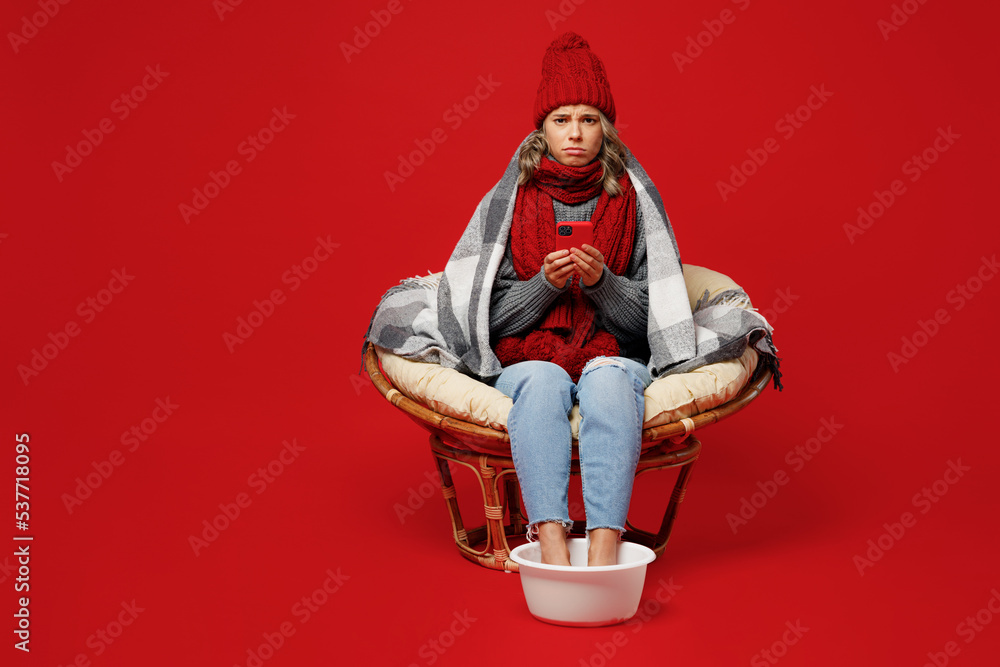 Full size young sad woman wear grey plaid scarf hat sit in chair soar ...