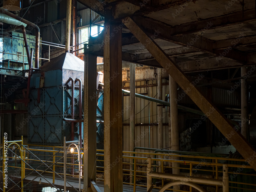 the interior of an abandoned factory with pipes and rusty metal ...