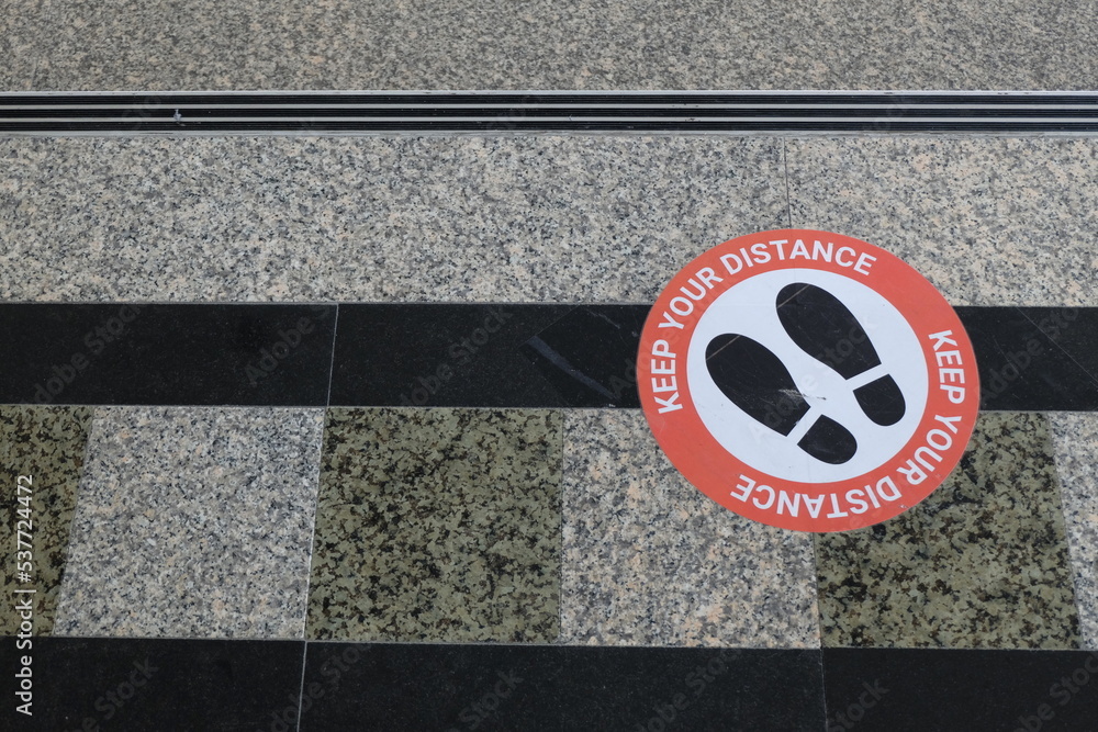 Warning signs posted on the ground to maintain distances in the shared ...