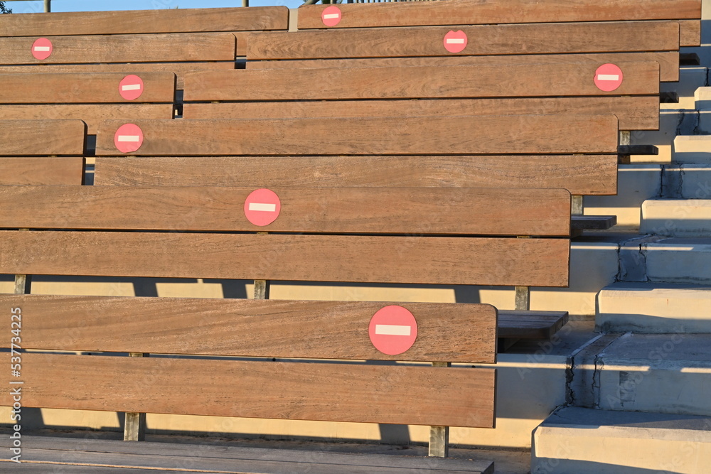 Rows of empty wooden benches arranged in cascades. There are small ...