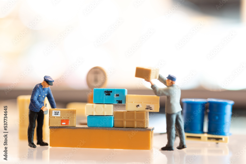 Miniature people postman officer on duty, he prepares to send a box to ...