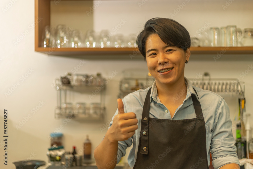 Young LGBT coffee shop owner puts her arm cross with confident standing ...