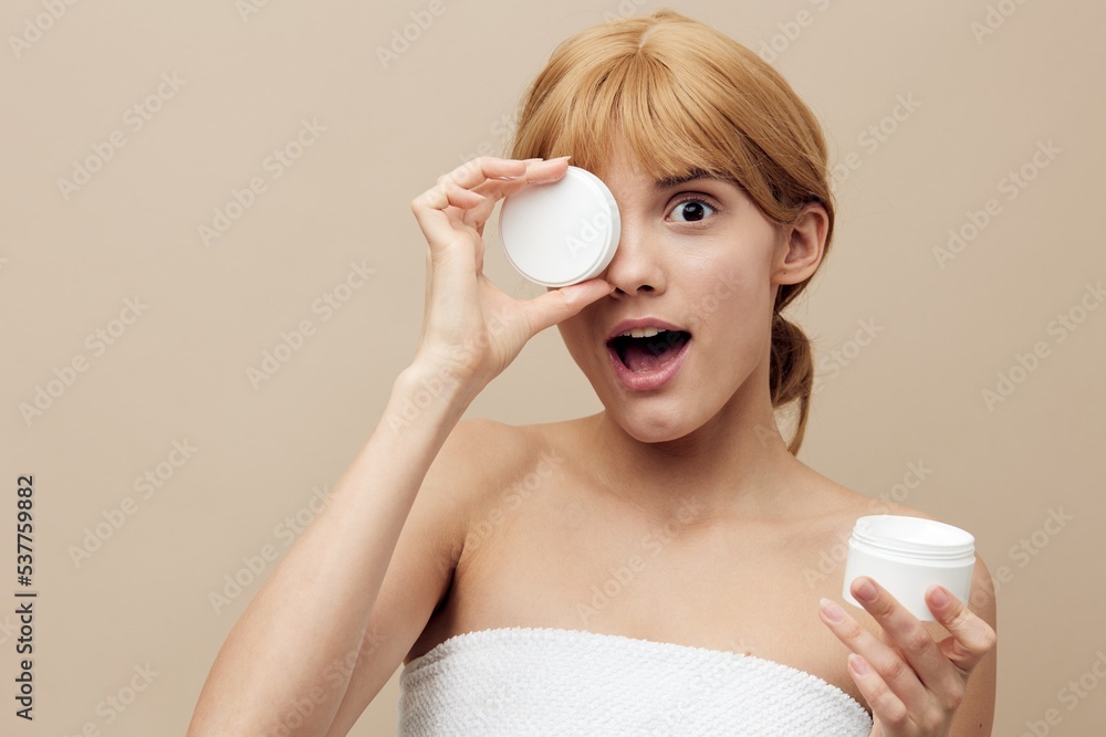 Horizontal studio shot. A gorgeous woman in a towel with clean skin, a ...