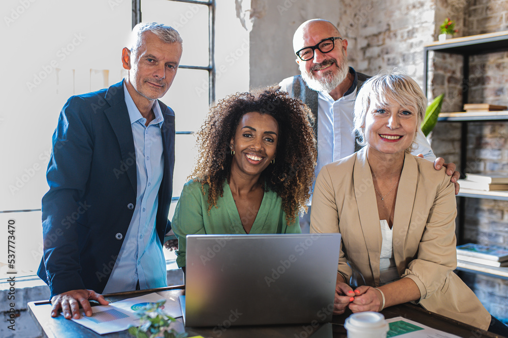 Portrait of a smiling group of diverse colleagues standing together at ...