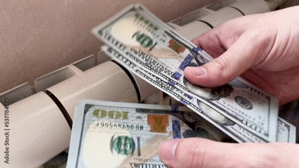 Dollars money banknotes are on heating radiator battery. Concept of ...