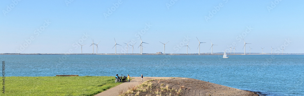 Recreating people sitting on the shore of the Eastern Scheldt estuary ...