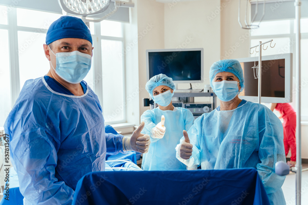 Team of surgeons tired and happy showing thrumb up finished the ...