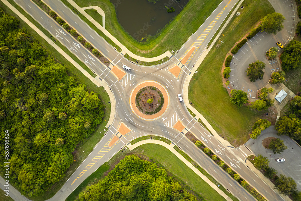 Aerial view of road roundabout intersection with moving cars traffic ...