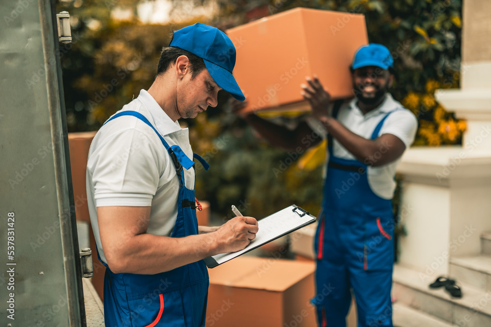House moving staff is moving a box full of stuff ready for loading into ...