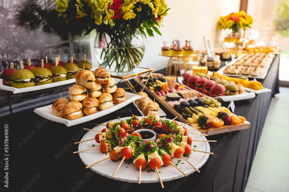 Big table with delicious cocktail of skewers, mini sandwiches ...