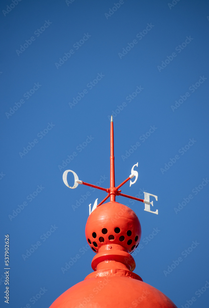 Red compass indicating wind direction in north, south, east, west with ...