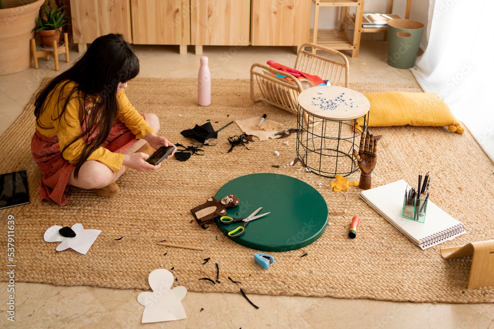 Cute girl making crafts for her homework at living room Stock Photo ...