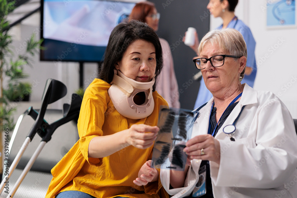 Physician consulting patient with cervical neck collar in hospital ...