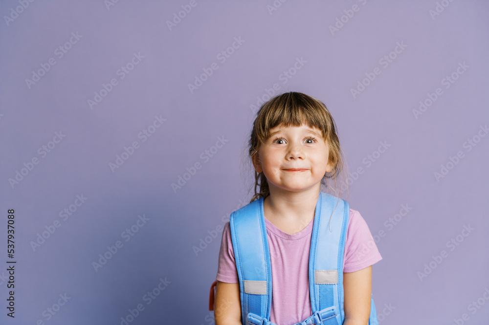 girl in front of purple background wearing her backpack for school ...