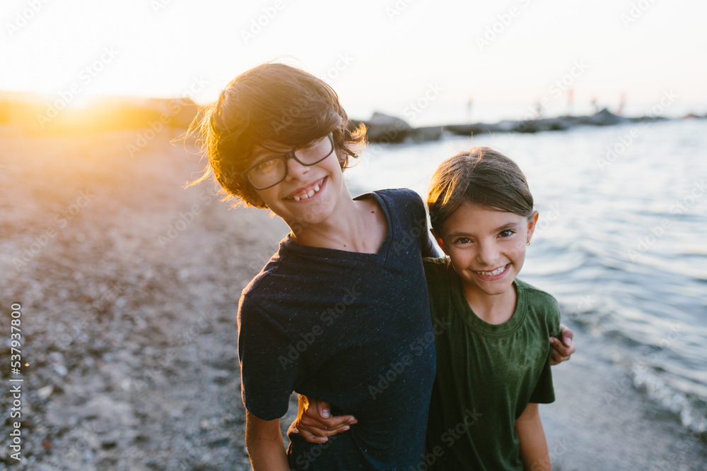 siblings lovingly hug eachother on the beach Stock Photo | Adobe Stock