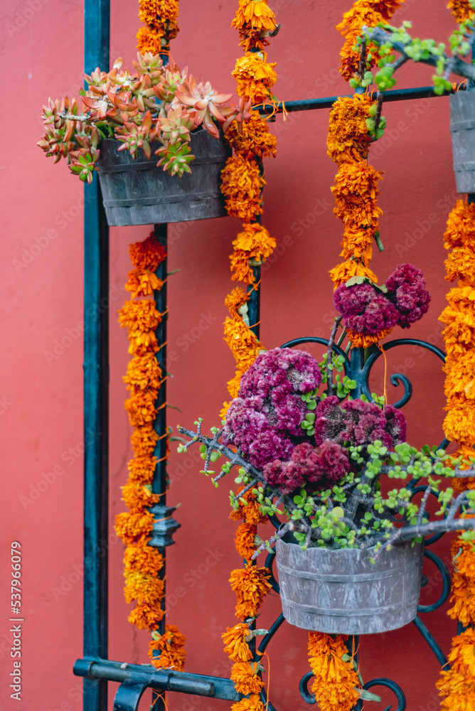 traditional vertical hanging altar with flower strings and pots with ...