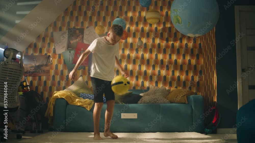 Young enthusiastic boy pratices football before the match in his room ...