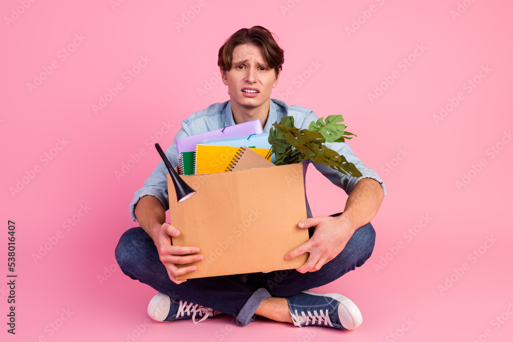 Full body photo of disappointed guy sit floor with carton box move ...