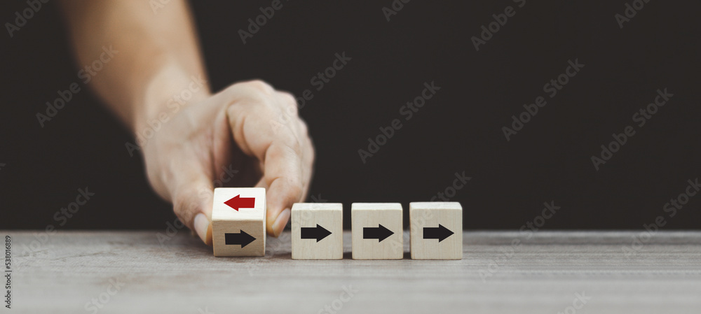 Hand flipping wooden cube block arrow from change left to right for ...