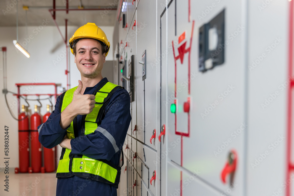 Electrical engineer wear helmet and show thump up near Power ...