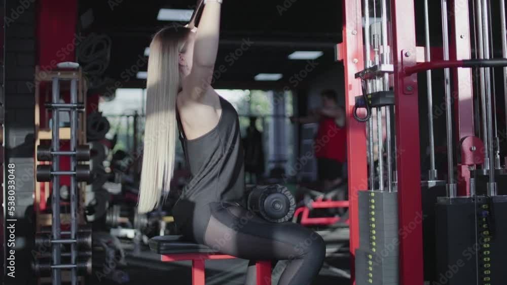 Side view of blonde woman does Lat pulldown at gym Stock Video | Adobe ...