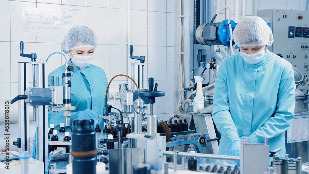 Women work on the packaging line. Preparing bottles for use. Female ...