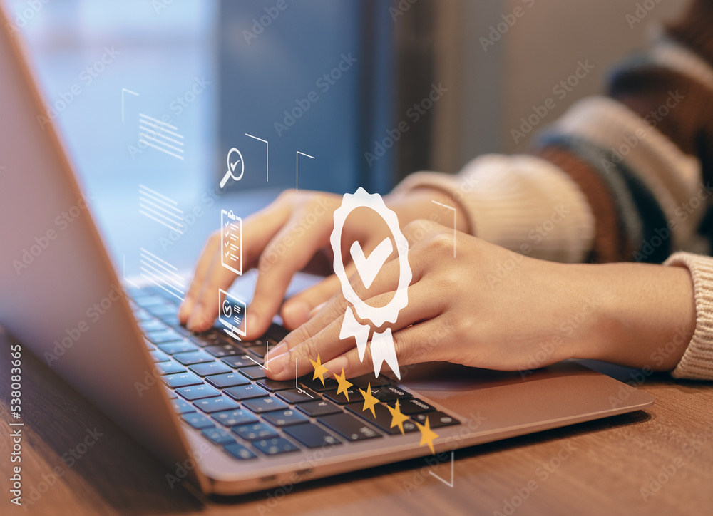 Businesswoman working on laptop with sign of the top service Quality ...