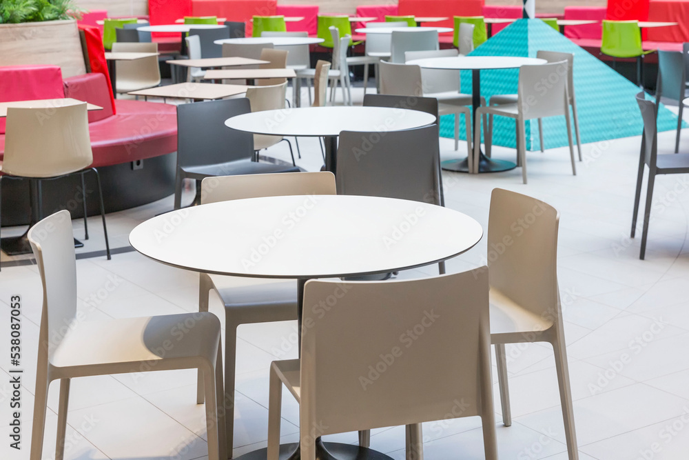 Empty tables in the cafe at the food court in the mall. Place for ...