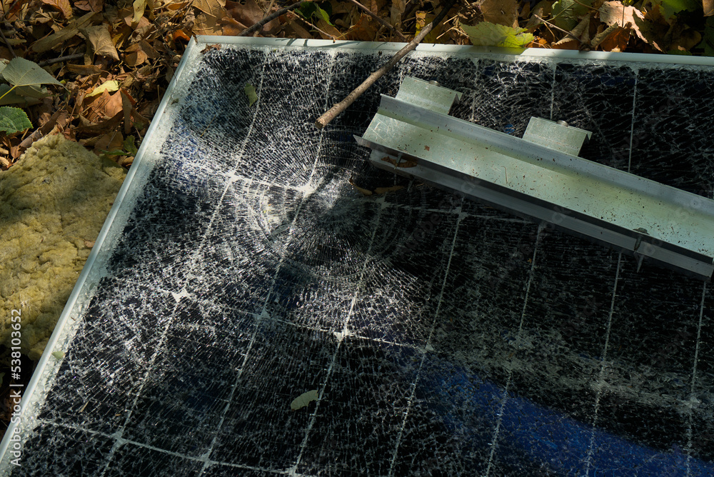 A broken solar panel, a torn panel mount lie on the ground. Consequences of a natural disaster ...