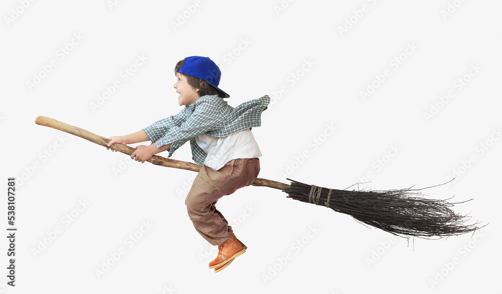 Happy boy is flying on a broomstick like a wizard. A child's fantasy ...
