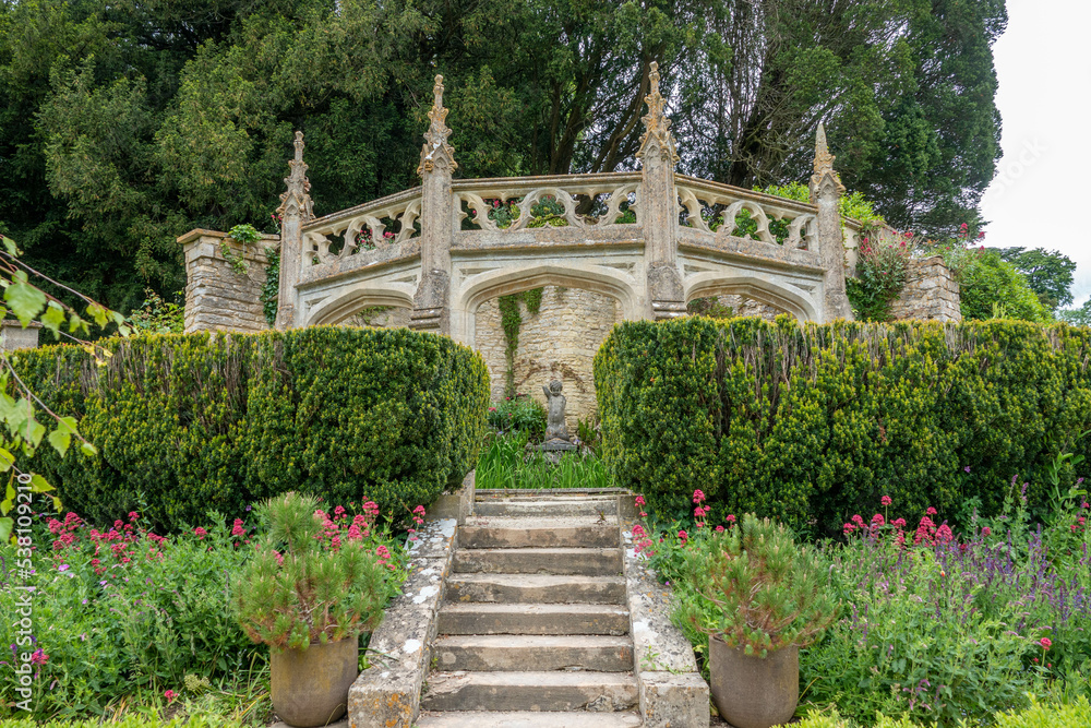 statue in front of old stone summerhouse in the Italian Garden at The ...