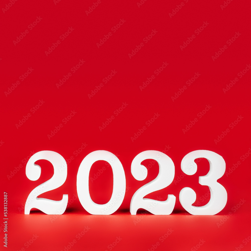 Red square banner with white wooden numbers 2023 stand at bottom. Merry ...