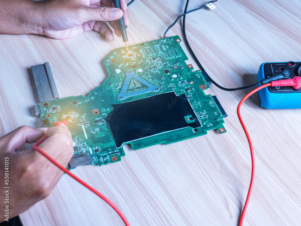 Hands use the red and black wires of the multimeter technology used to ...