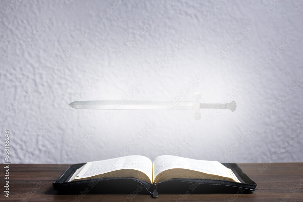 The Holy Bible is open. The Word of God is a sword. Stock Photo | Adobe ...