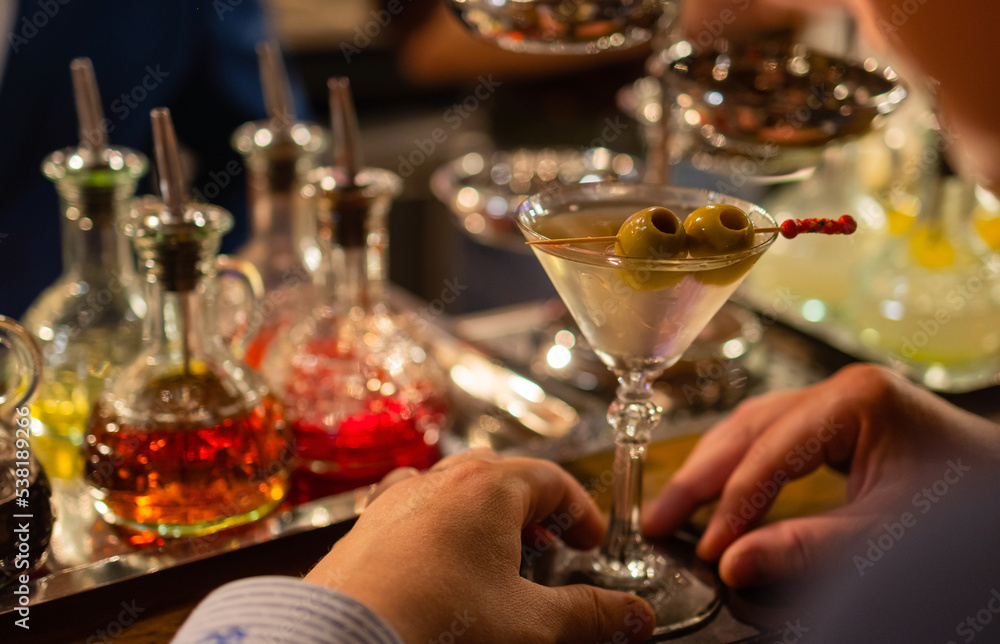 martini with green olives on a table in bar. Stock Photo | Adobe Stock