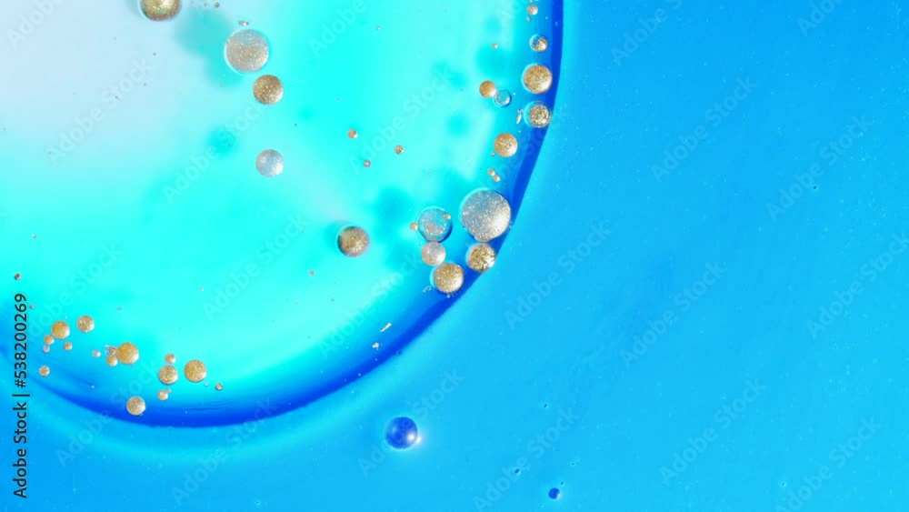 Mixing oil and blue paint forms beautiful texture. Golden and pearl ...