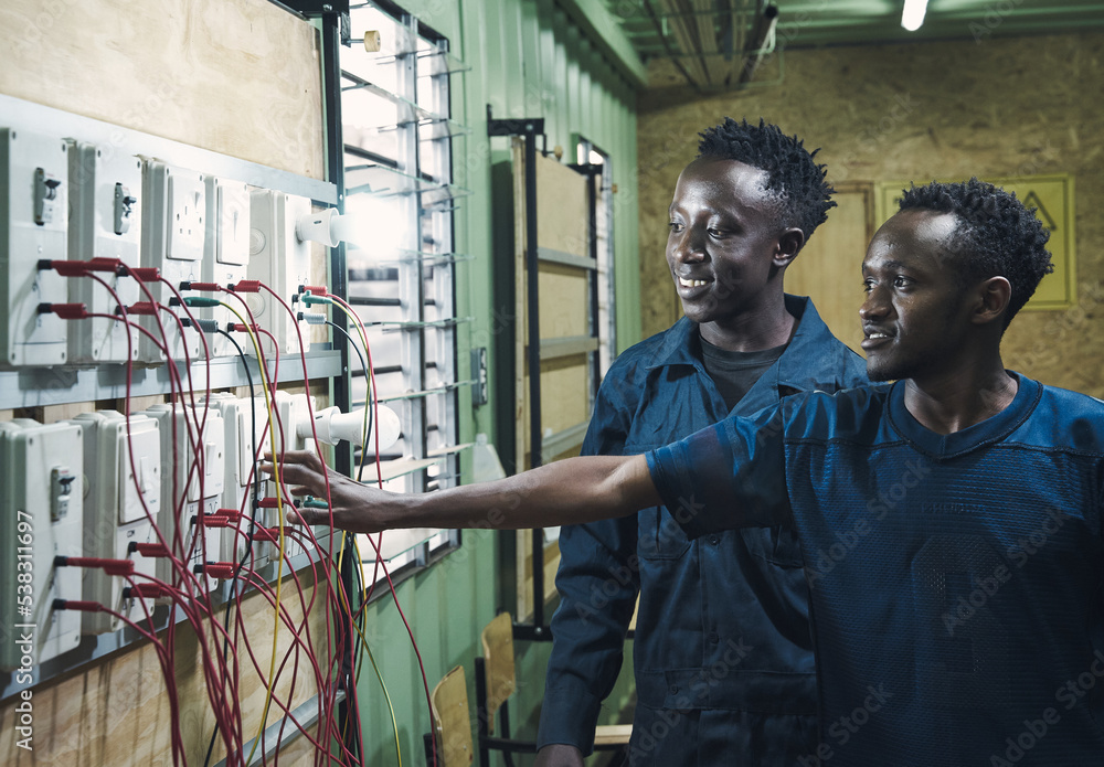 Young black men in a vocational training center, learning with ...