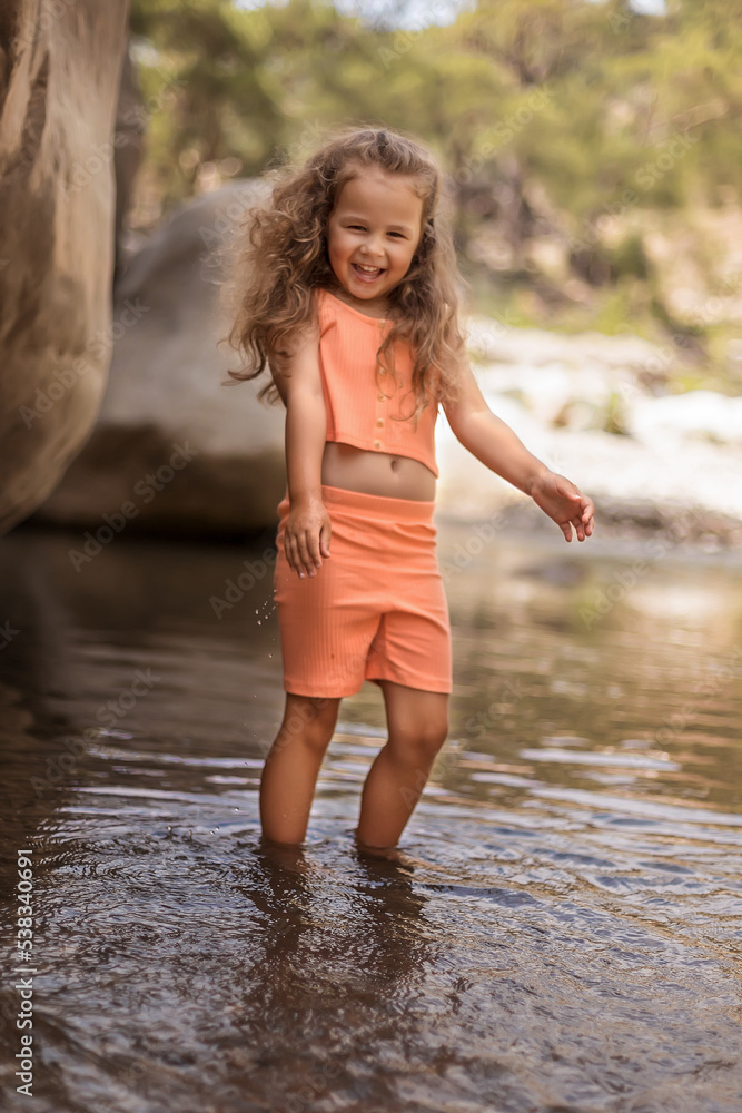 little girl and a splash of water. smiling child. a girl with flowing ...