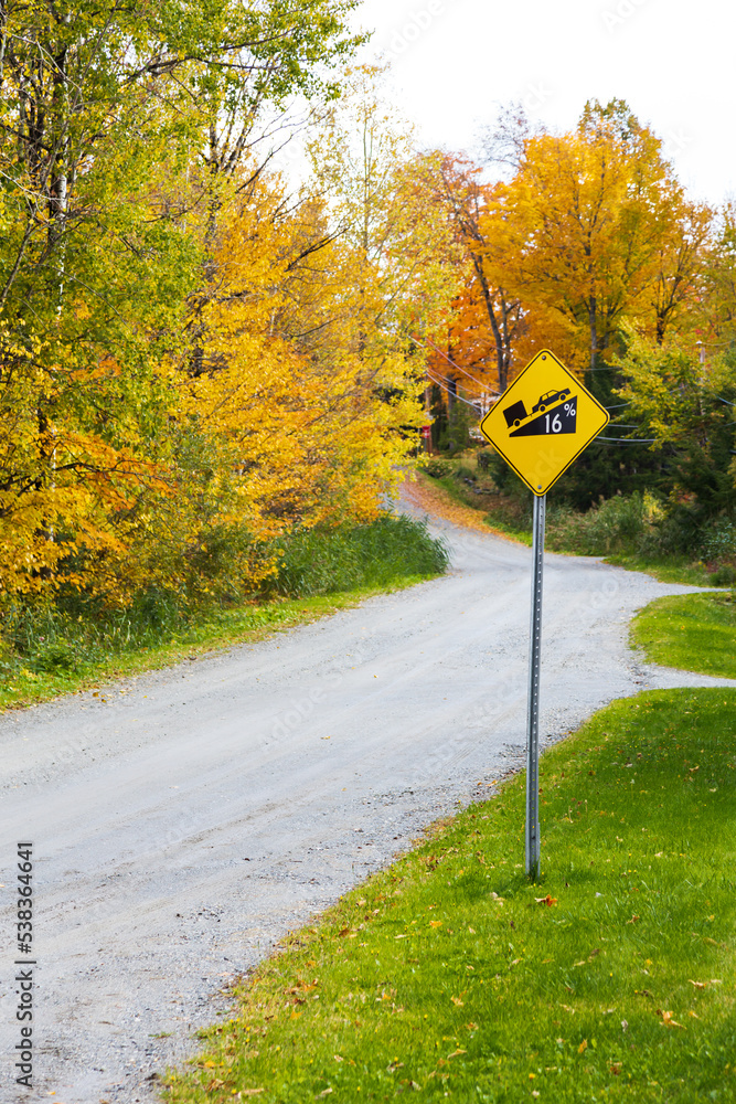 Vertical view of yellow traffic sign with 16% slope angle warning seen ...